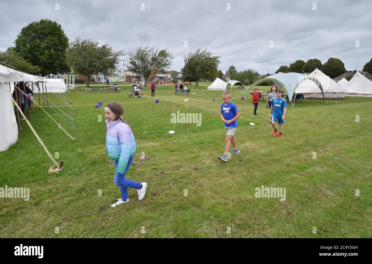 Children walk between tents set up as classrooms at Llanishen Fach ...