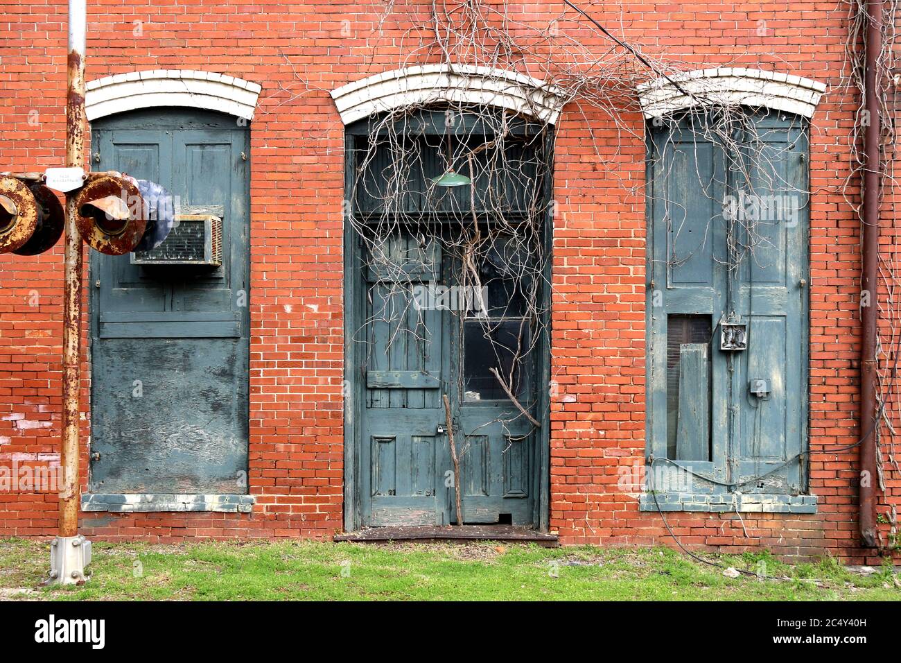an abandoned old train depot building front with boarded up door and ...
