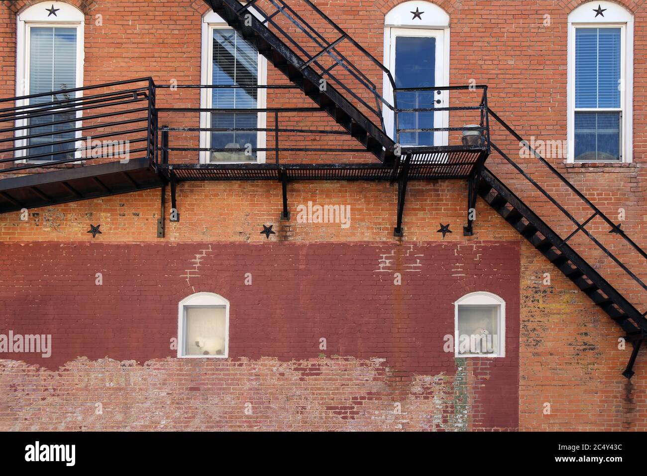 arched white windows behind back alley fire escape stairs at an old ...