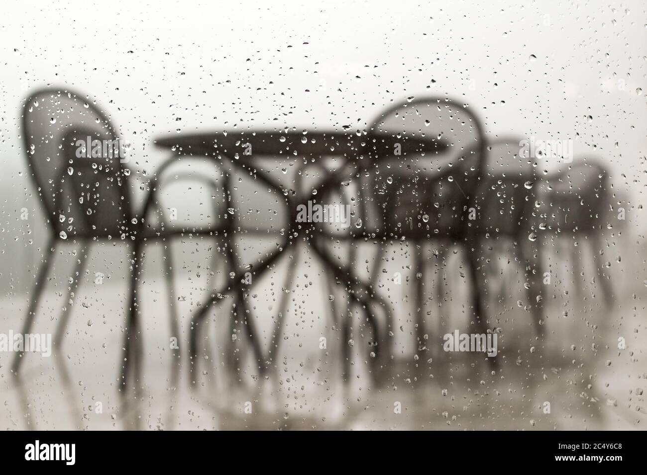 water drops on glass window; restaurant terrace view through window ...