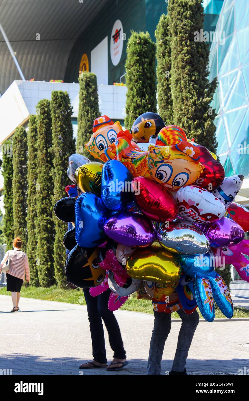 Guy carries a lot of colored balloons Stock Photo - Alamy