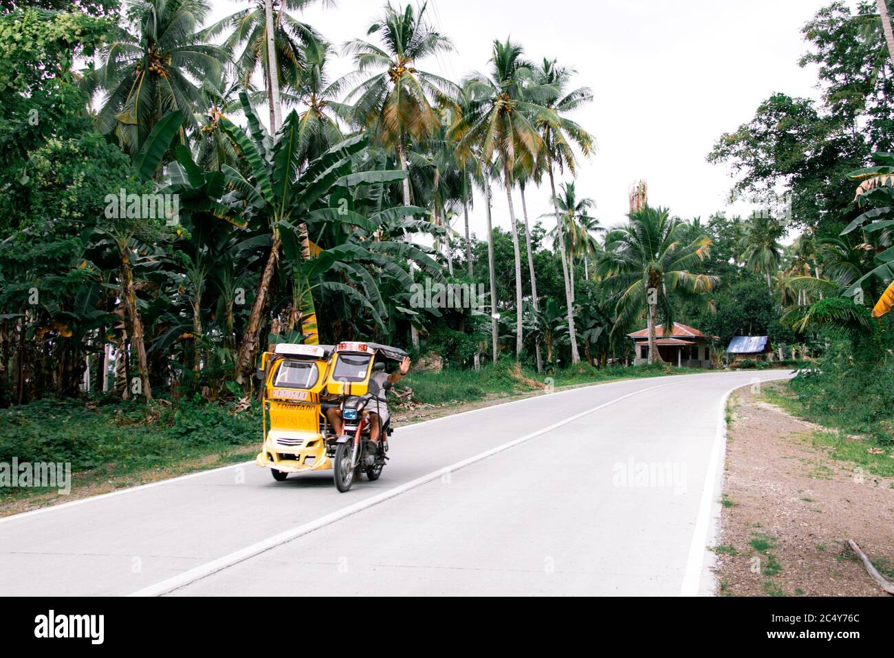 A local motorcyclists waves hello as he passes by on an open road Stock ...