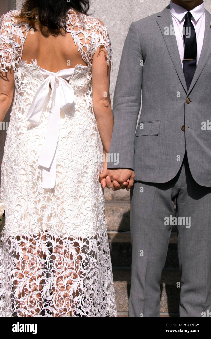 A stylish bride and groom standing side by side on their wedding day ...