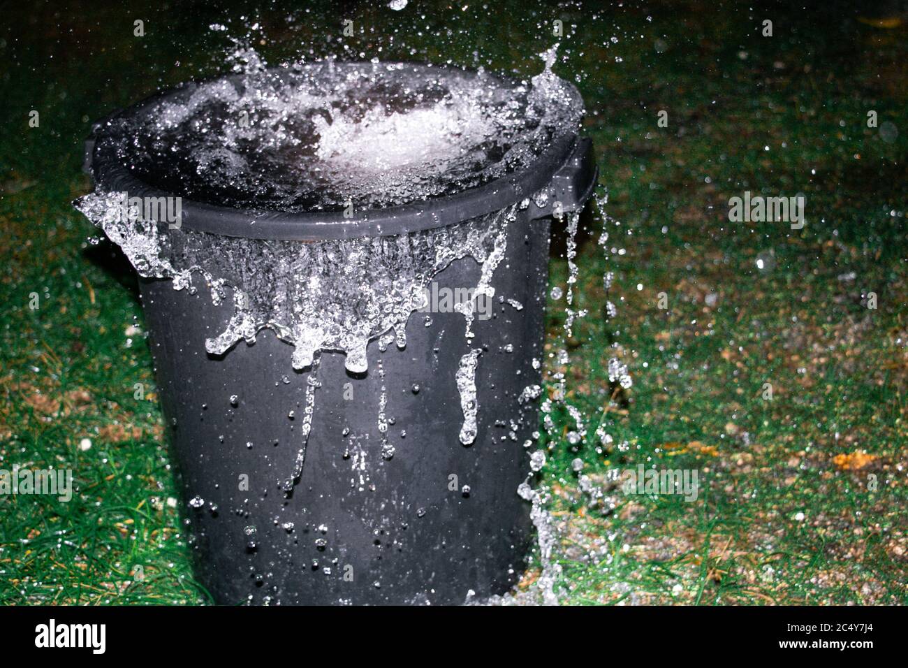 A large black bin overflows with rain water from a tropical storm Stock ...