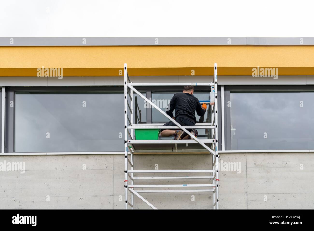 window cleaner on a portable scaffolding rack cwashing windows of a ...