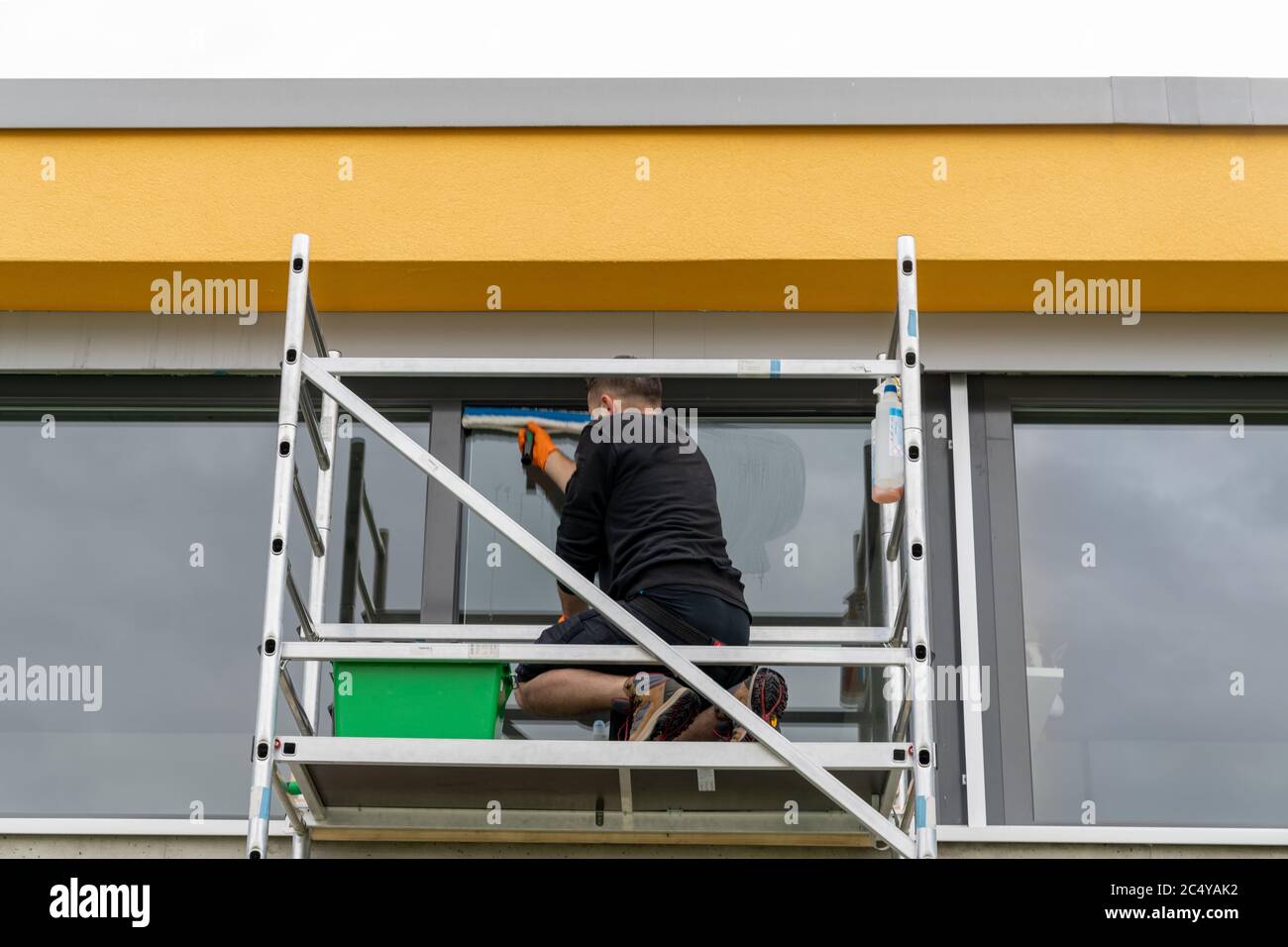 window cleaner on a portable scaffolding rack cwashing windows of a ...