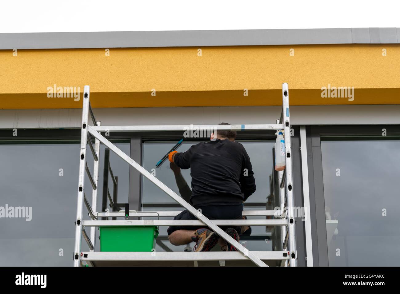 window cleaner on a portable scaffolding rack cwashing windows of a ...