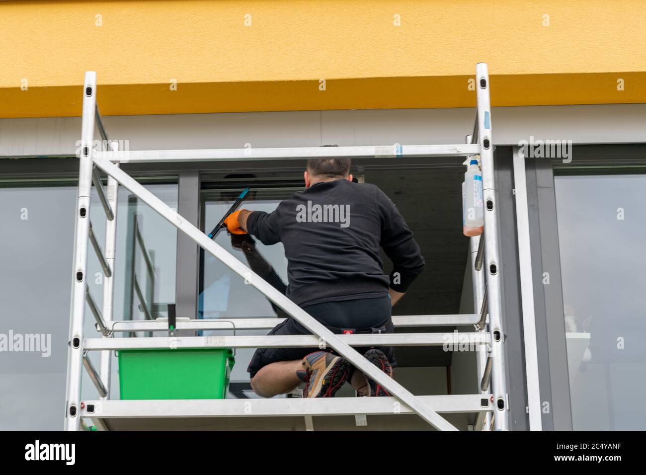 window cleaner on a portable scaffolding rack cwashing windows of a ...