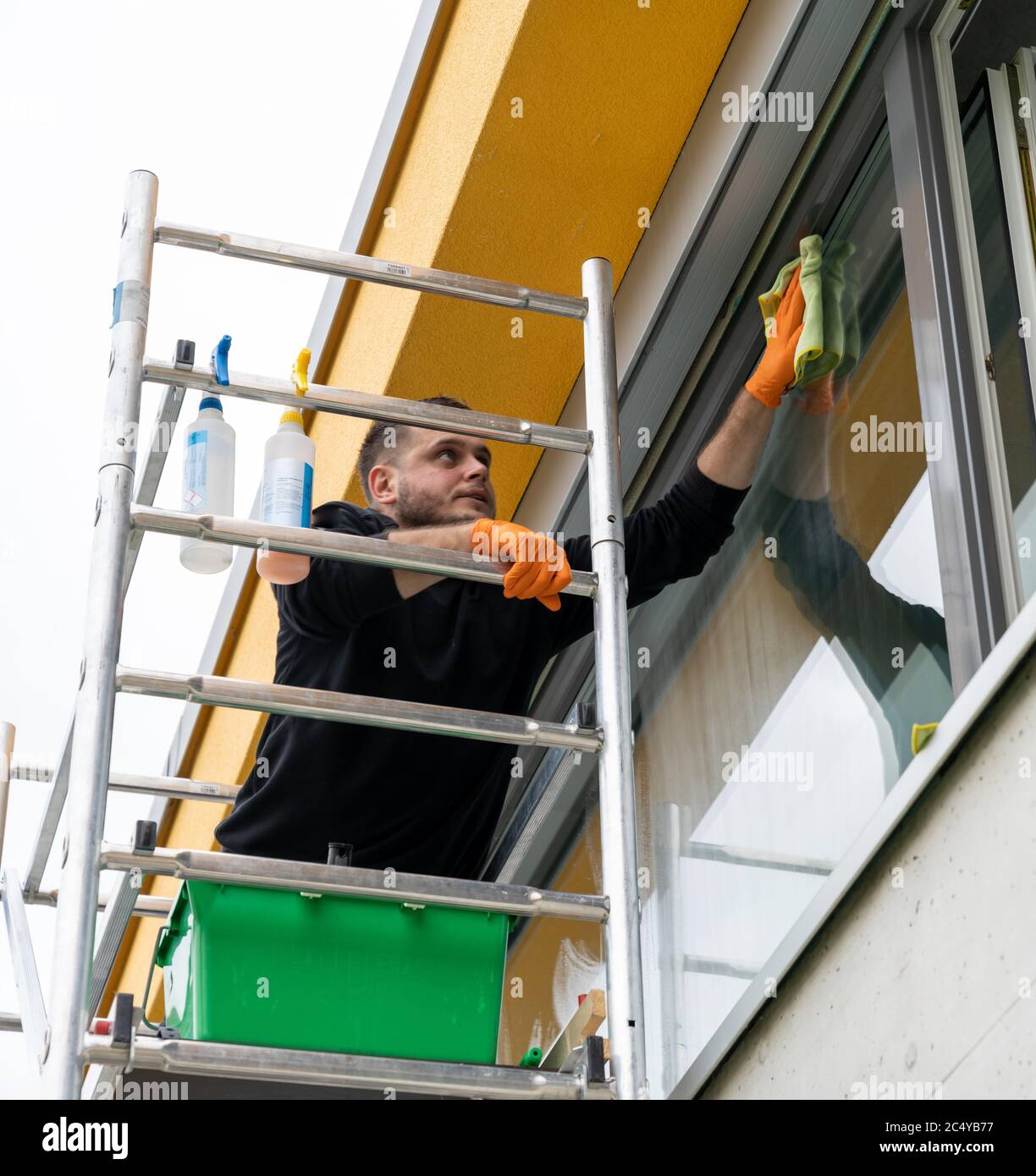 window cleaner on a portable scaffolding rack cwashing windows of a ...