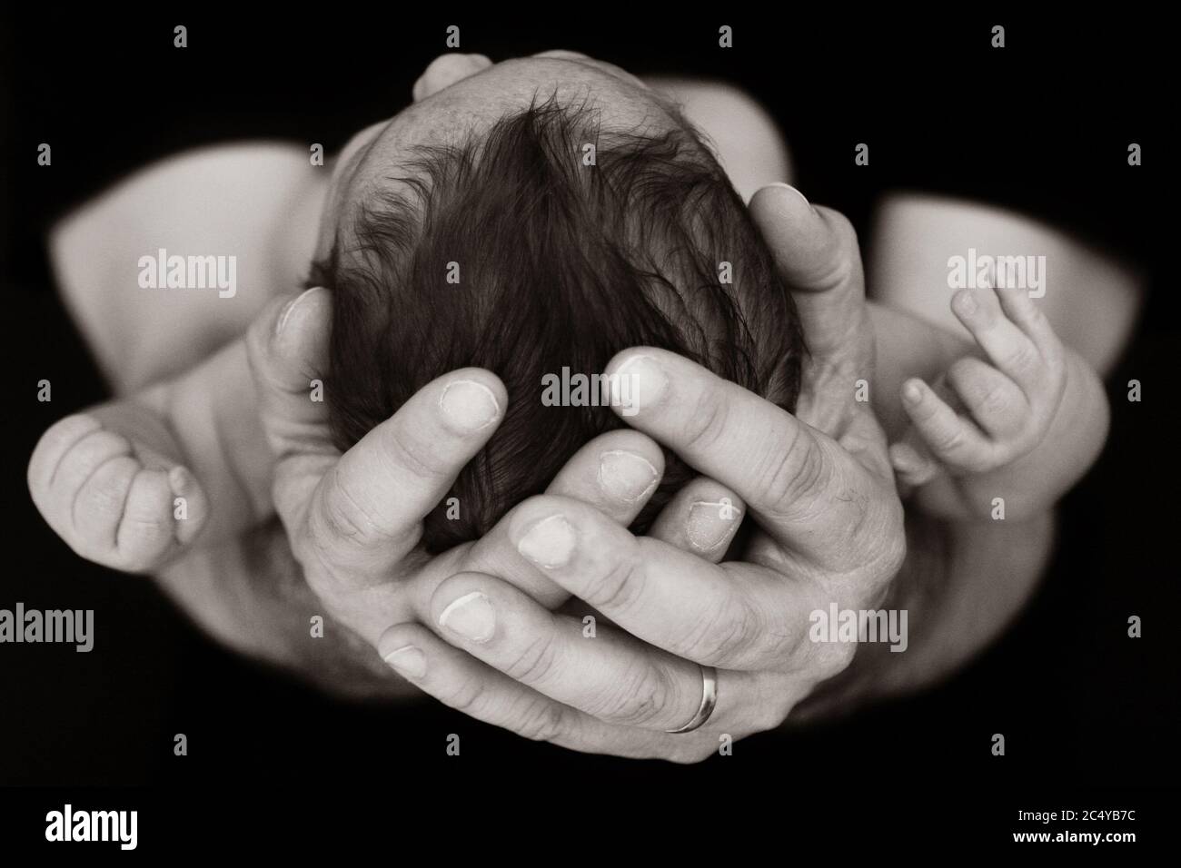 Father holding baby's head in his hands Stock Photo - Alamy