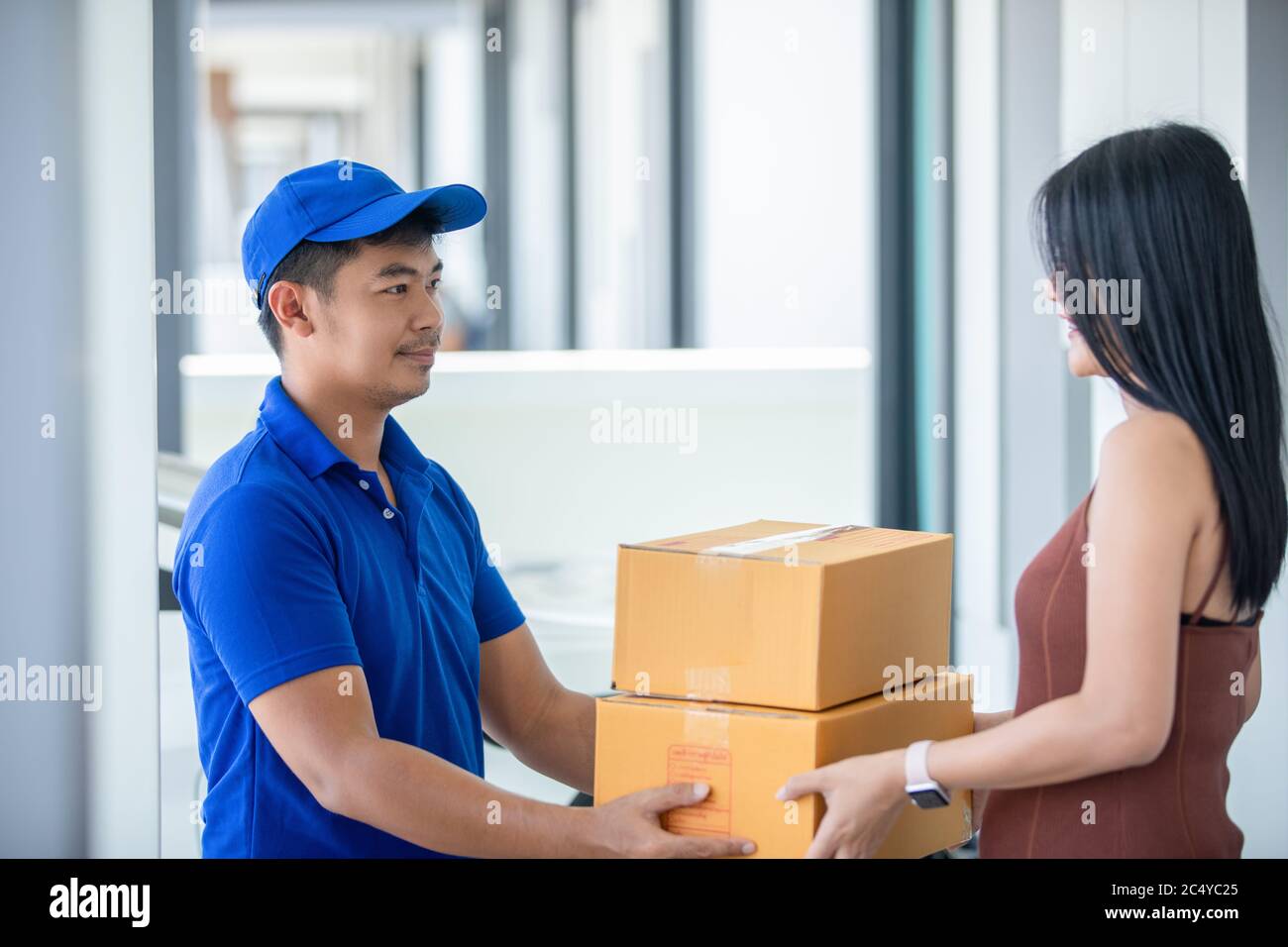 Asian delivery servicemen wearing a blue uniform with a bluecap and ...