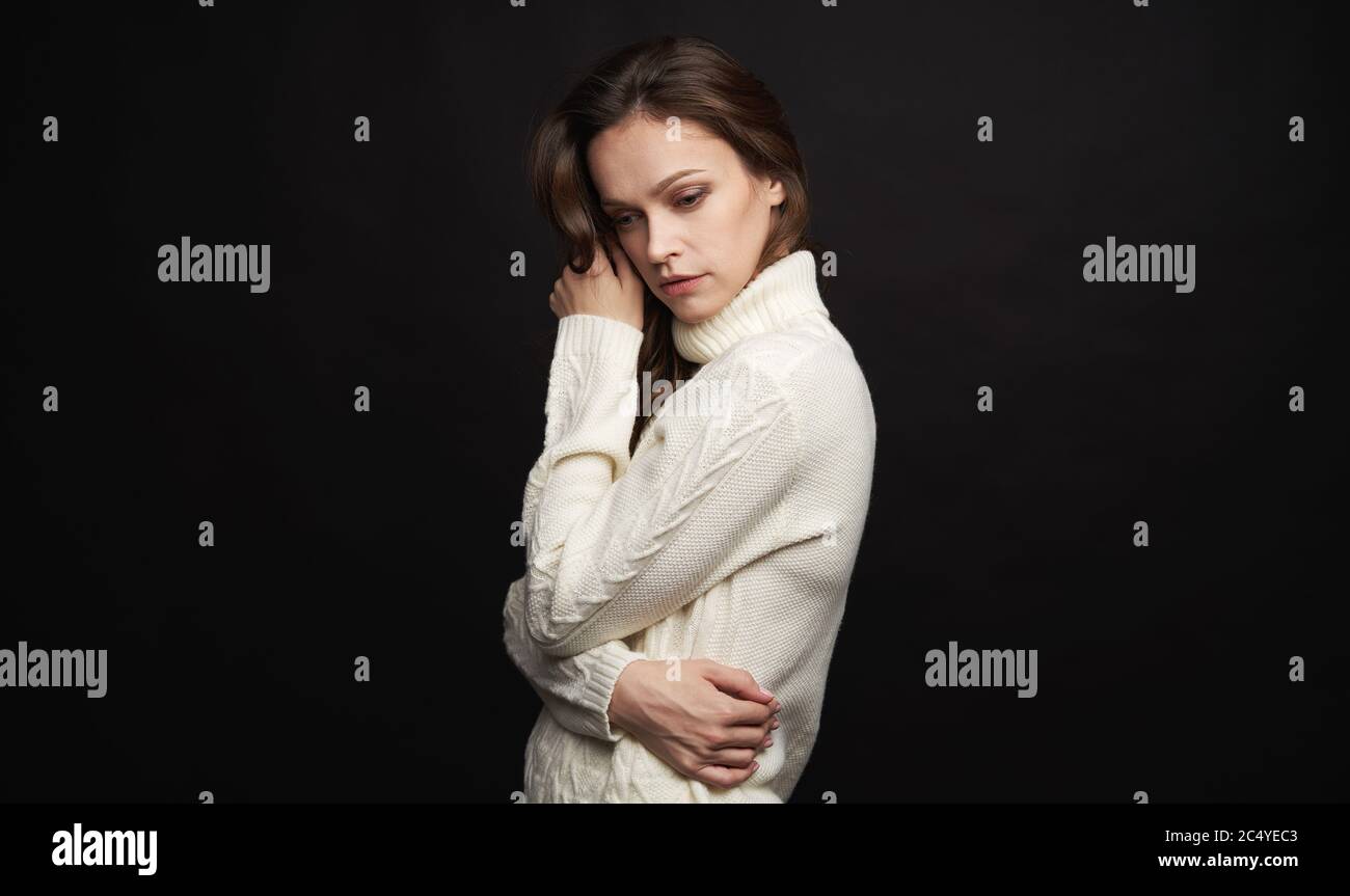 Sad woman is looking down. Pretty girl on black studio background Stock ...