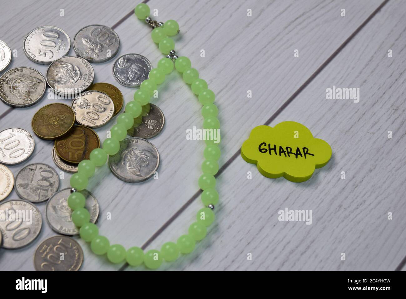 Gharar text on sticky notes and coins isolated on office desk. It means ...
