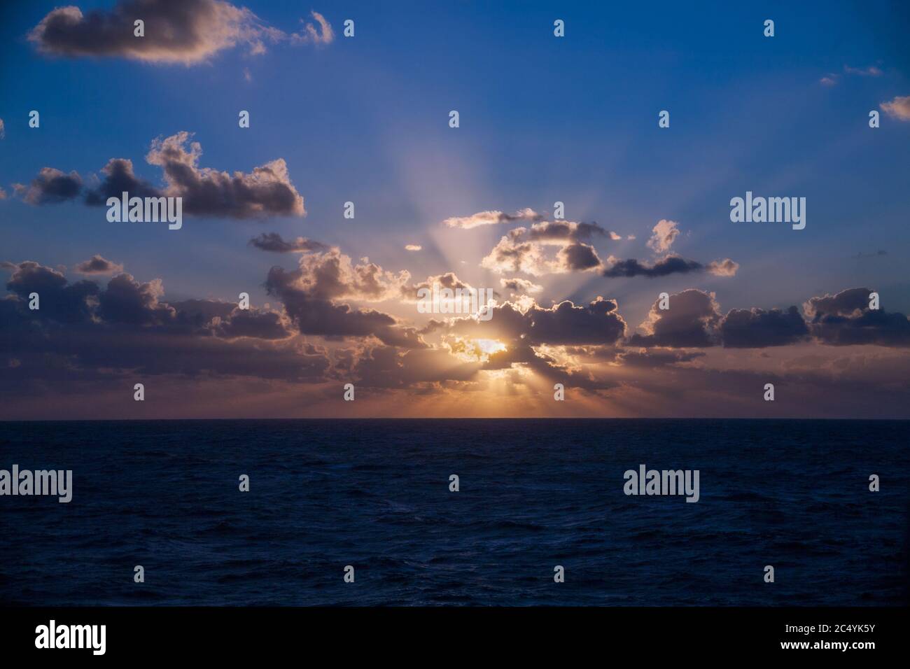 Ocean Sunset, morning clouds, and sunstreaks Stock Photo - Alamy