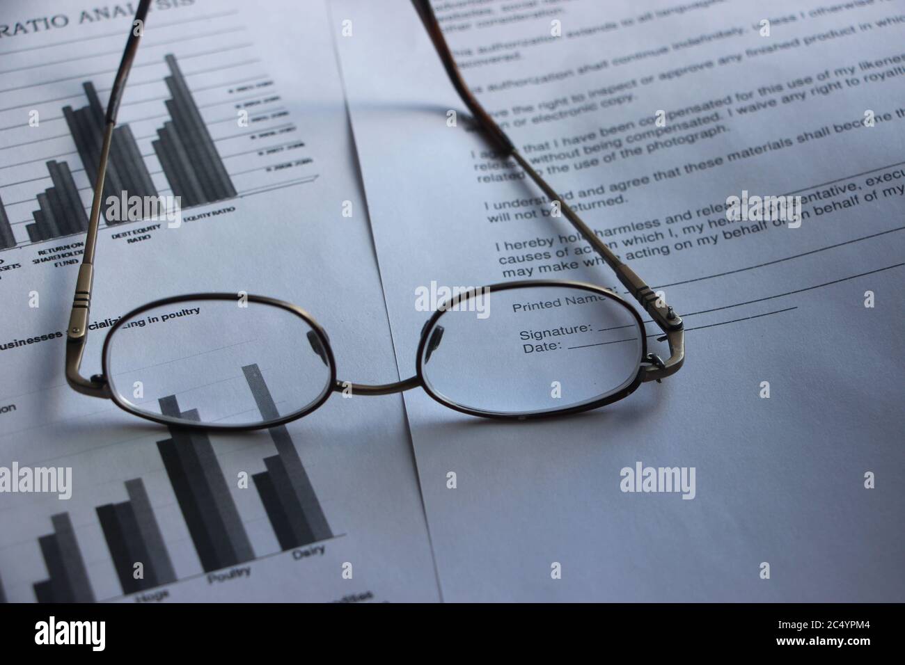 Glasses on the background of financial report with diagram graphs ...
