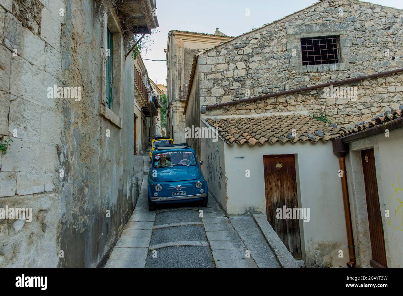 Tourists on a tour in old Fiats 500 through the narrow streets of ...