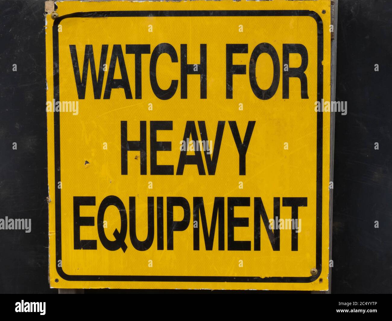 a yellow construction site warning sign saying Watch For Heavy ...