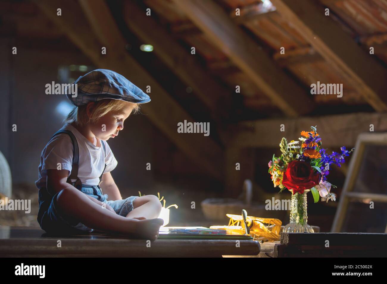 Cute beautiful child, blond kid, reading book and playing with ...