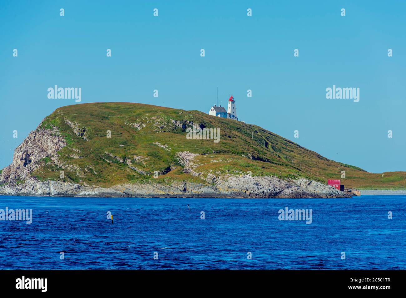 View of lighthouse on an island in front of Vardo, a town in northern ...