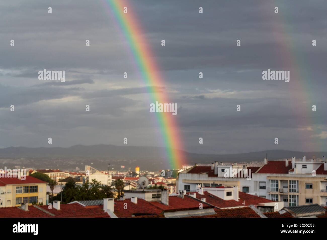Double rainbow over buildings Stock Photo - Alamy