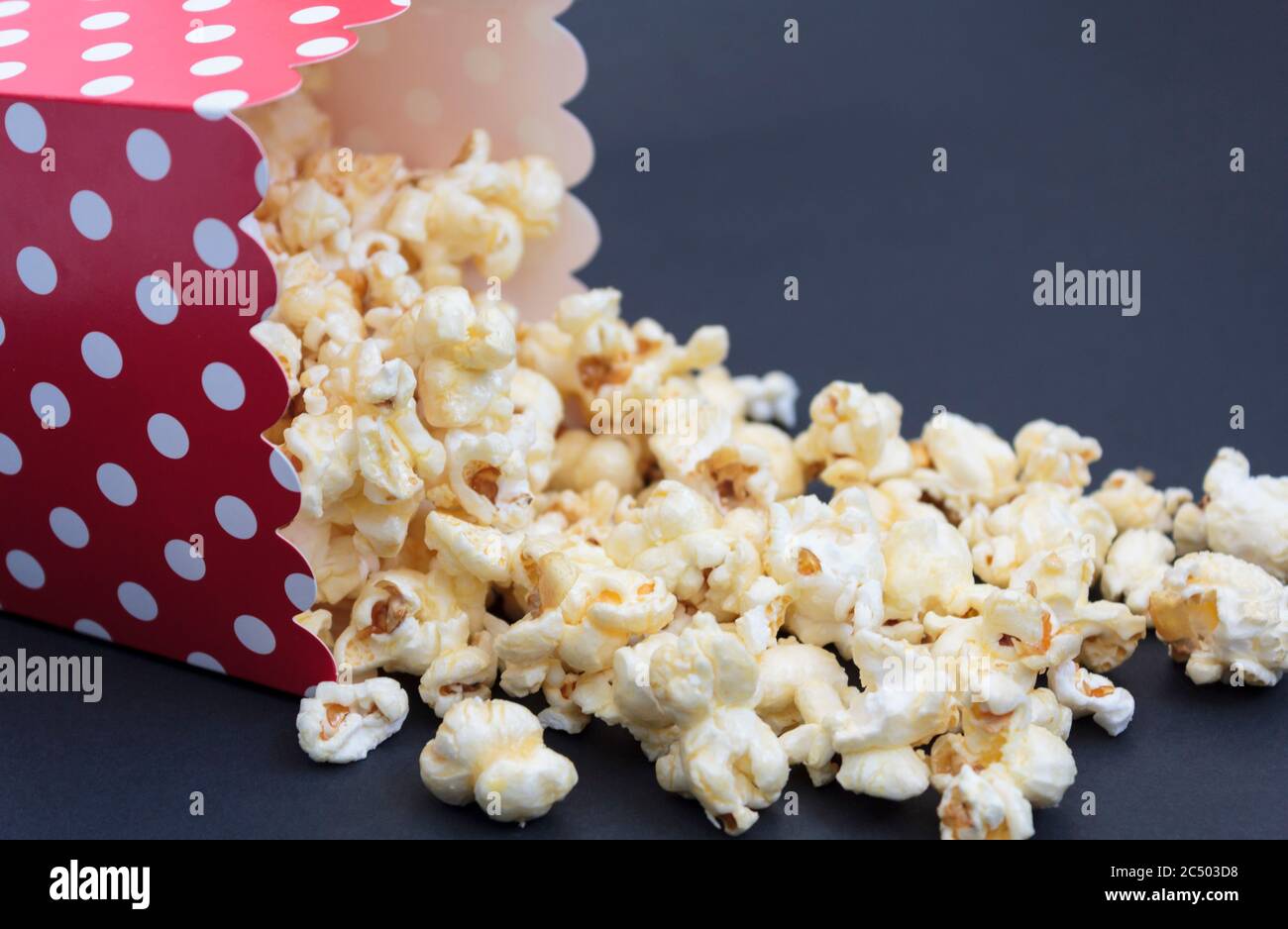 Popcorn falling out of the box on black background Stock Photo - Alamy