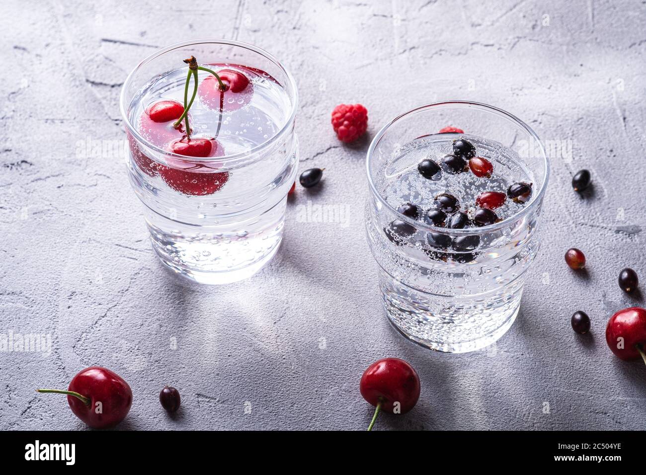 Fresh cold sparkling water drink with cherry, raspberry and currant ...