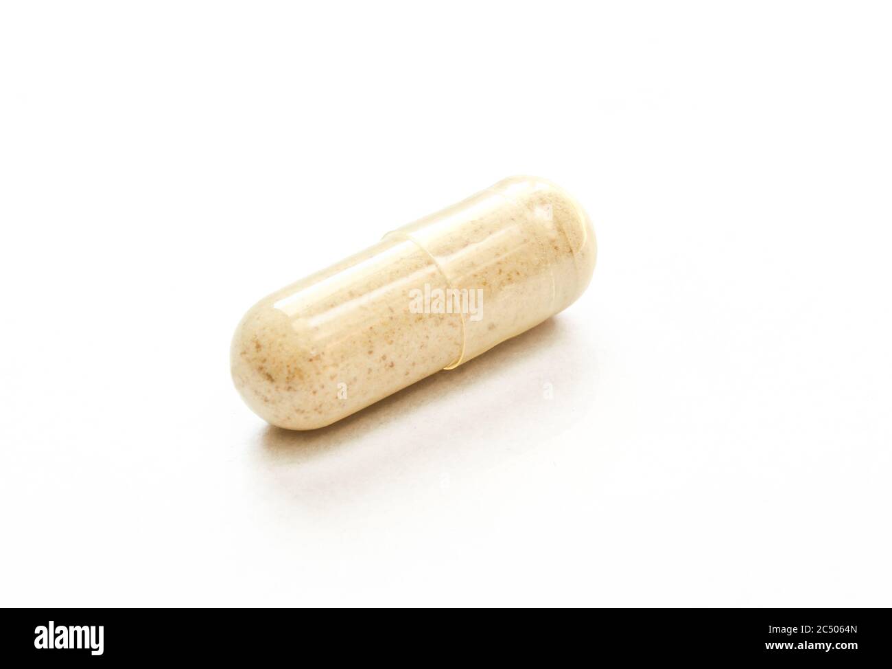 Transparent capsule filled with brown powder. Single pill isolated ...