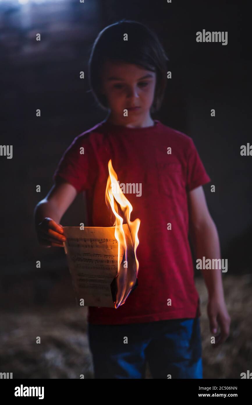 Preteen child, burning paper in the attic, seting it on fire Stock ...
