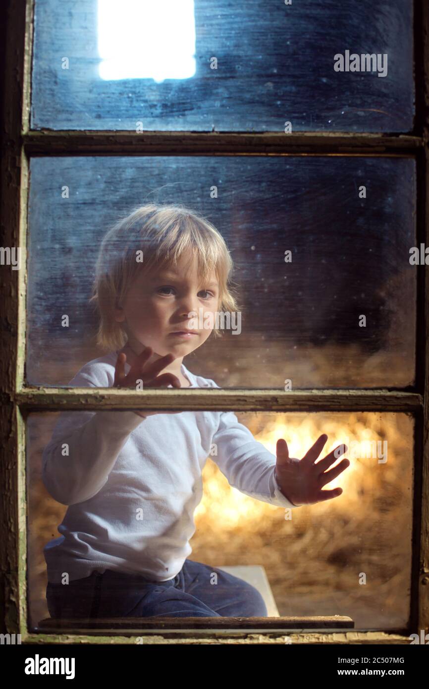 Blond child behind the window, looking outside at the moon Stock Photo ...