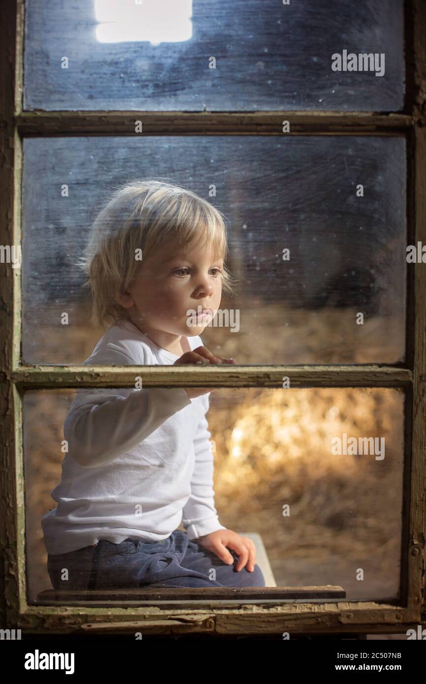 Blond child behind the window, looking outside at the moon Stock Photo ...
