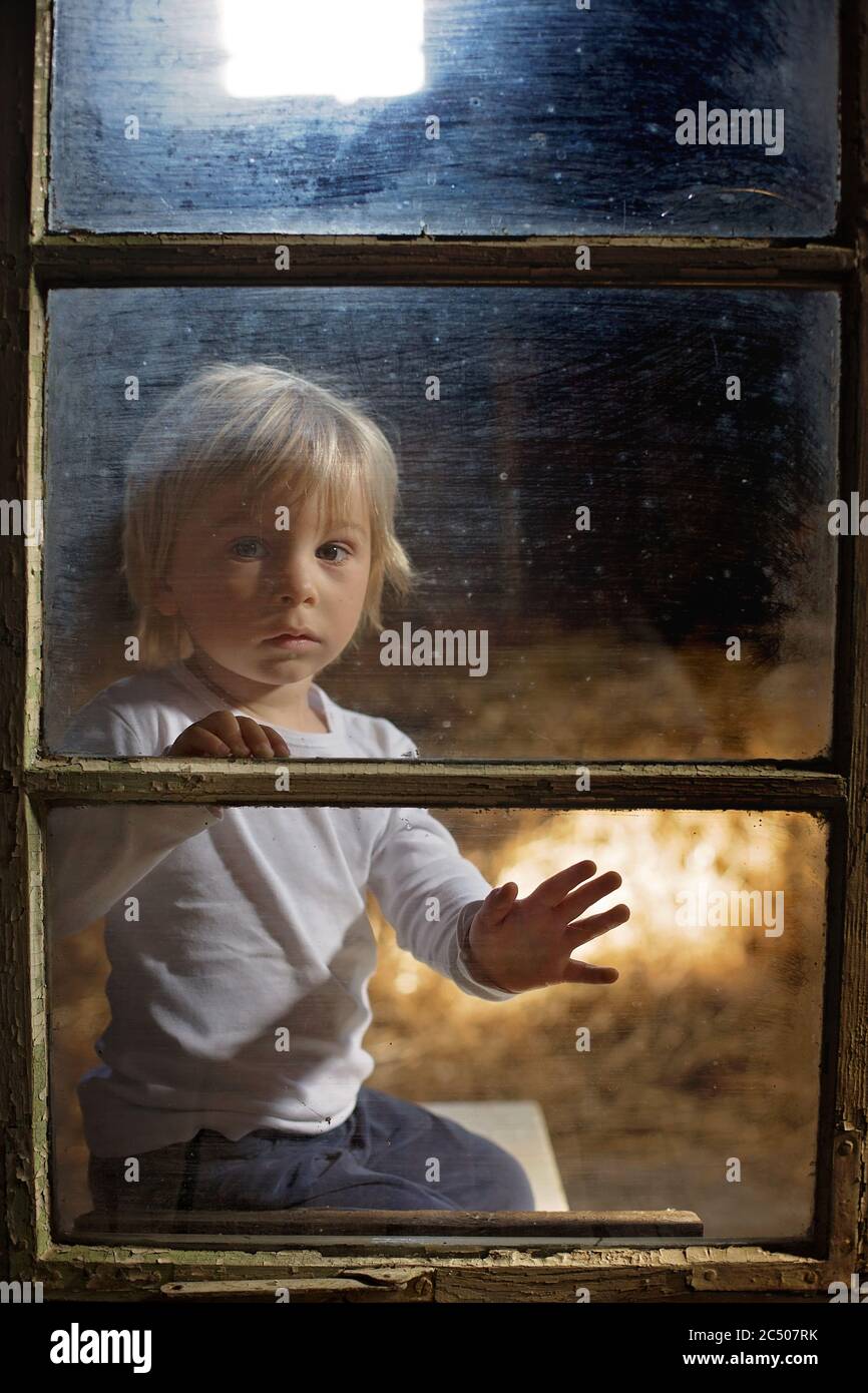 Blond child behind the window, looking outside at the moon Stock Photo ...