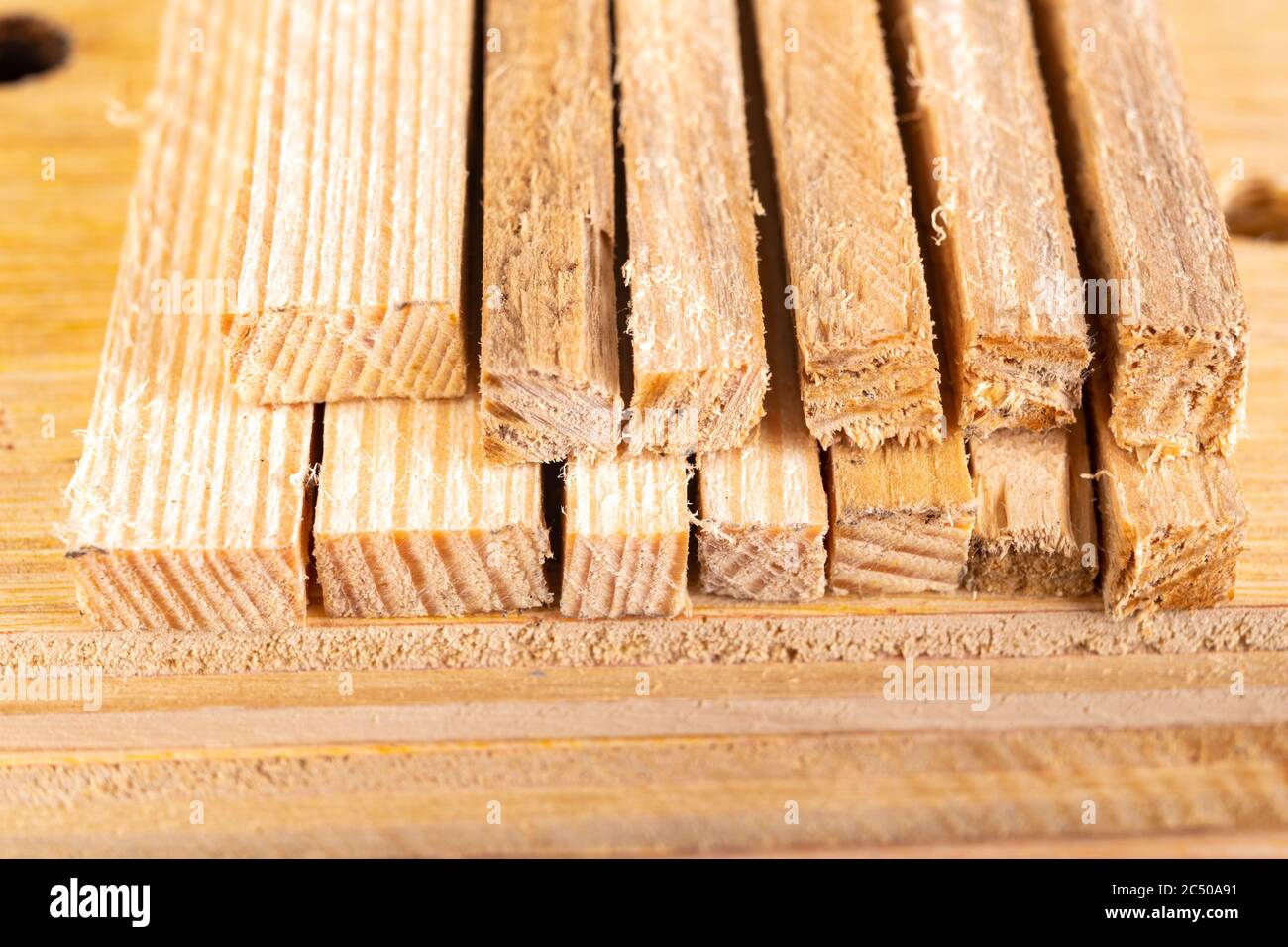 Wooden raw slats stacked. Pieces of wood used to build furniture. Light ...