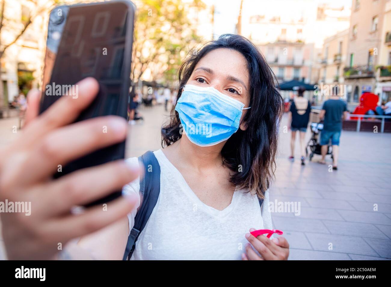 young tourist woman taking selfie with face mask, example of tourism ...