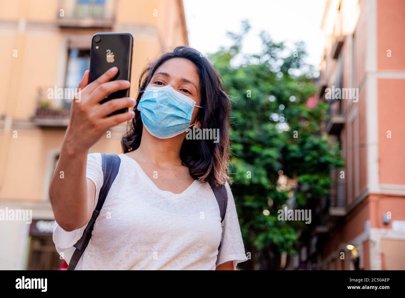 young tourist woman taking selfie with face mask, example of tourism ...