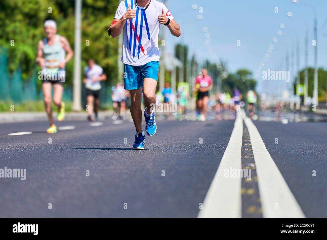 Marathon runners on city road. Running competition. Street sprinting ...