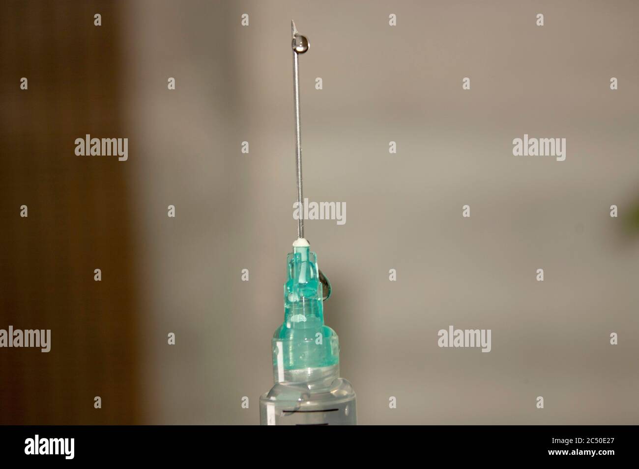 Syringe expelling liquid to remove air through the needle before ...