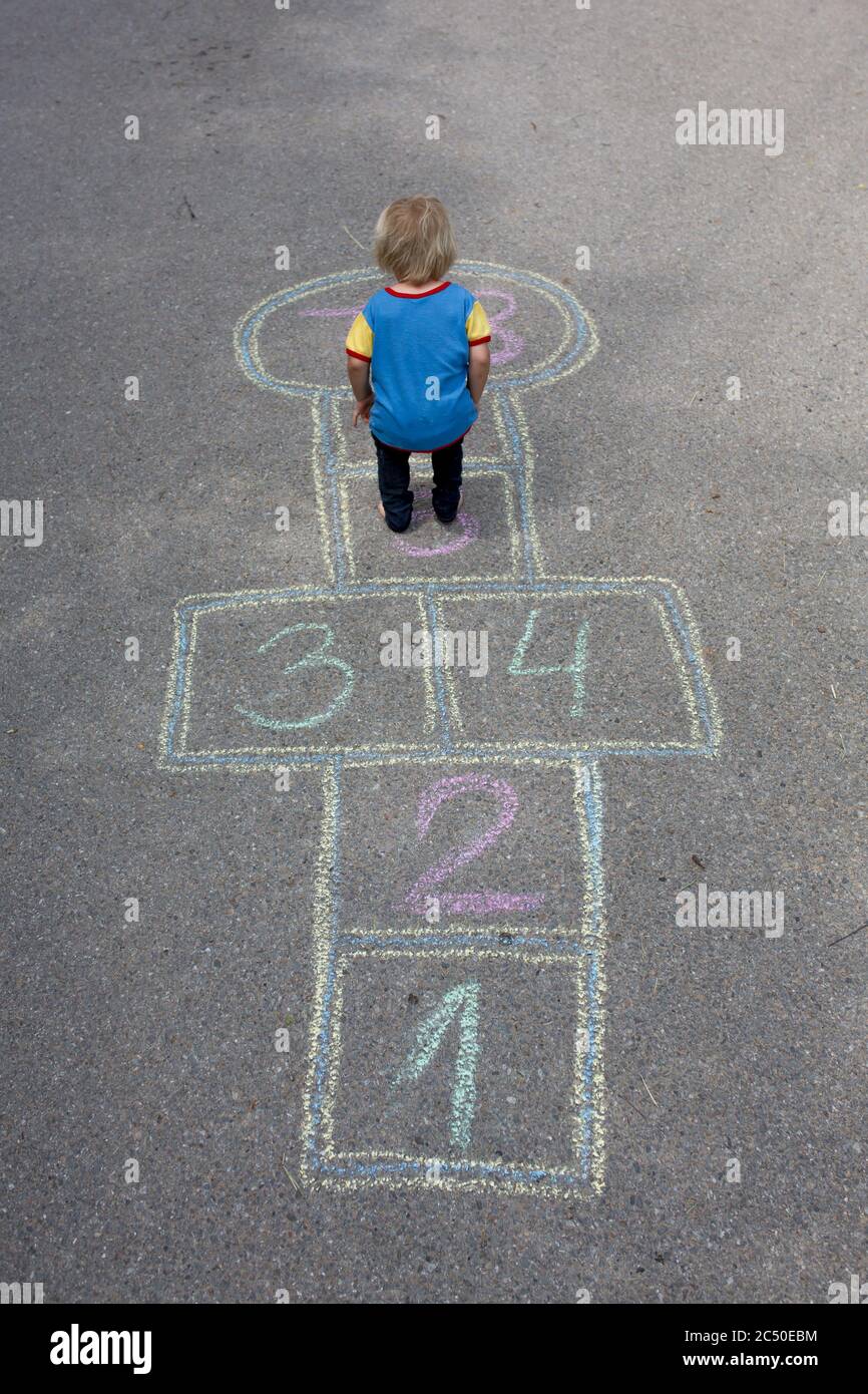 Child, blond boy, playing hopscotch on the street, summertime Stock ...