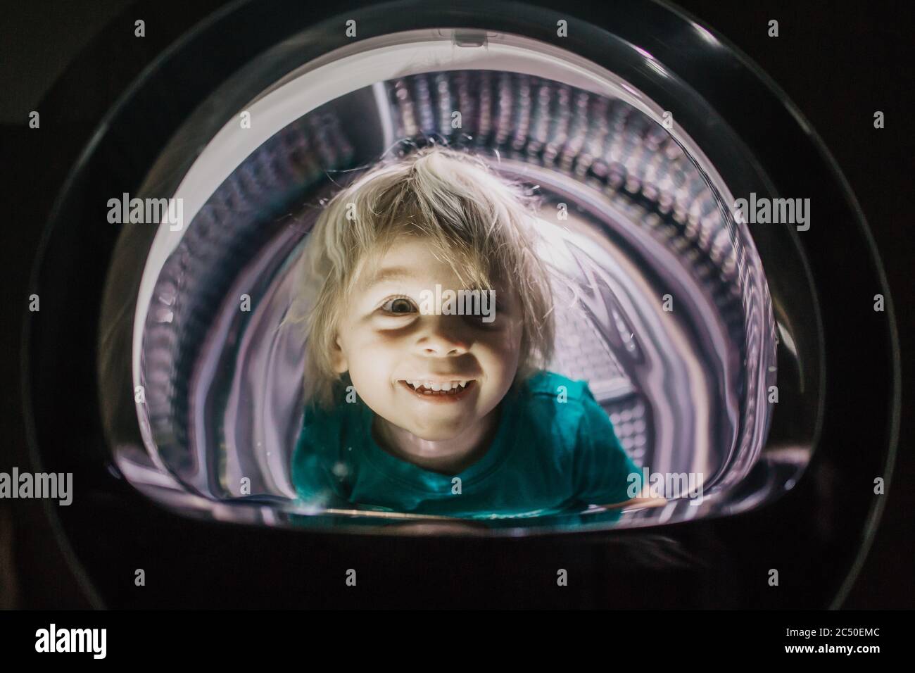Happy child, sitting in thumble dryer, smiling happily Stock Photo - Alamy