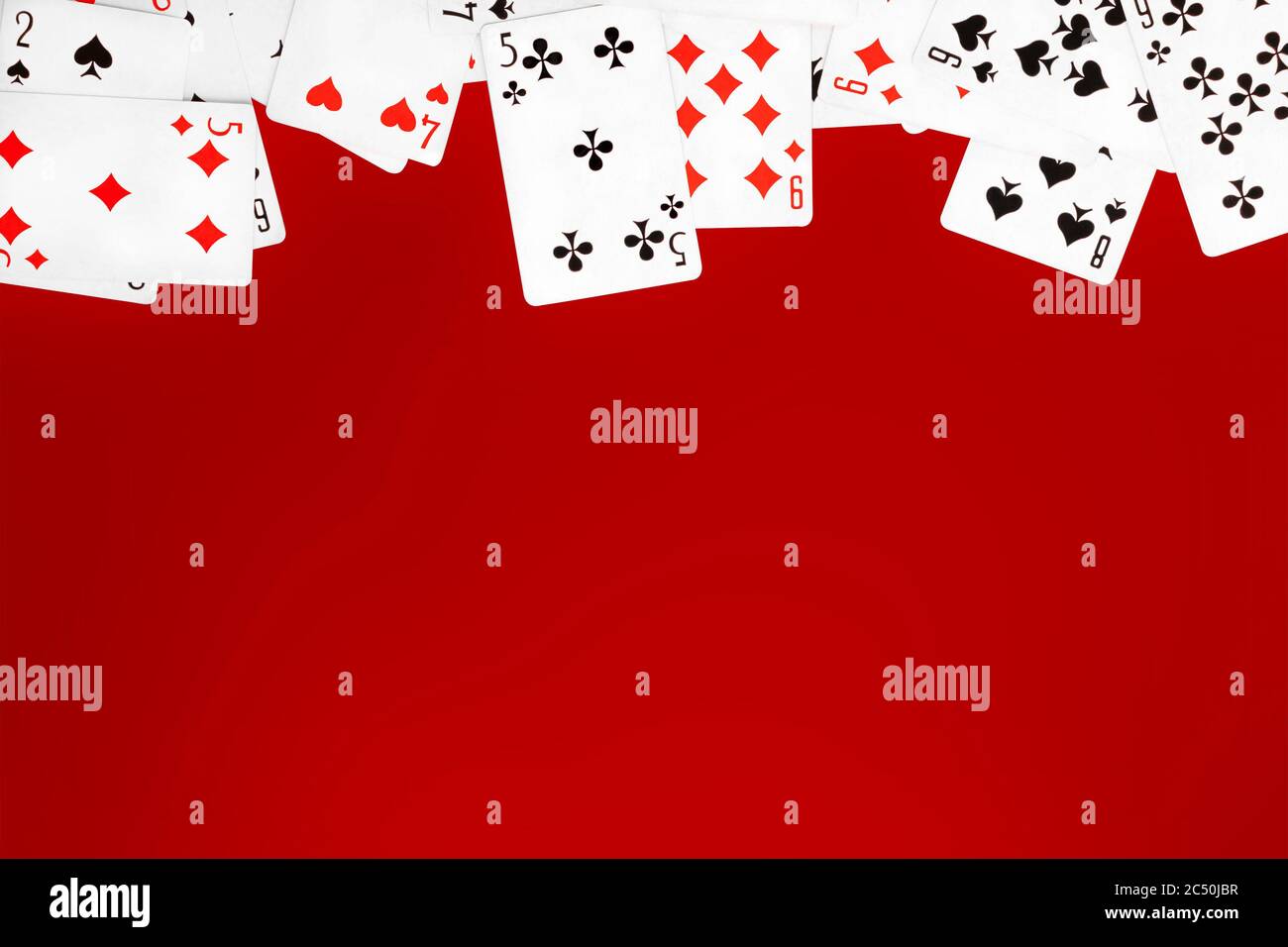 Deck of playing cards on red background copy space Stock Photo - Alamy