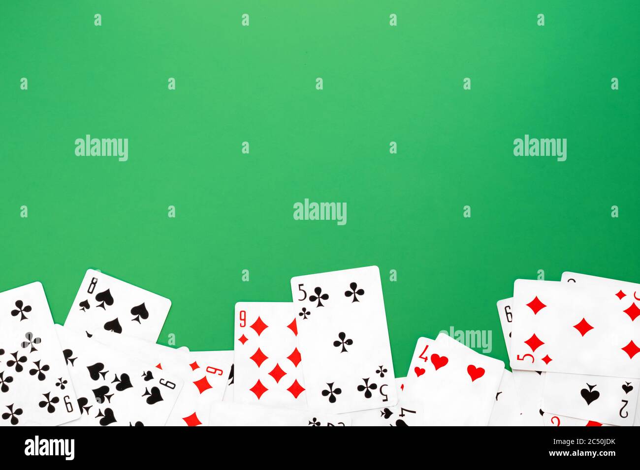 Deck of playing cards on green background copy space Stock Photo - Alamy