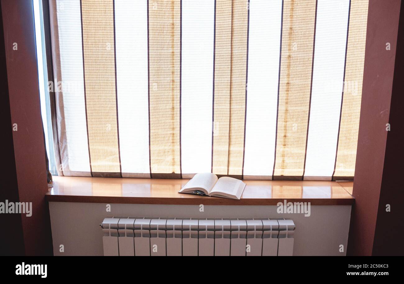 book on the ledge of a large window Stock Photo - Alamy