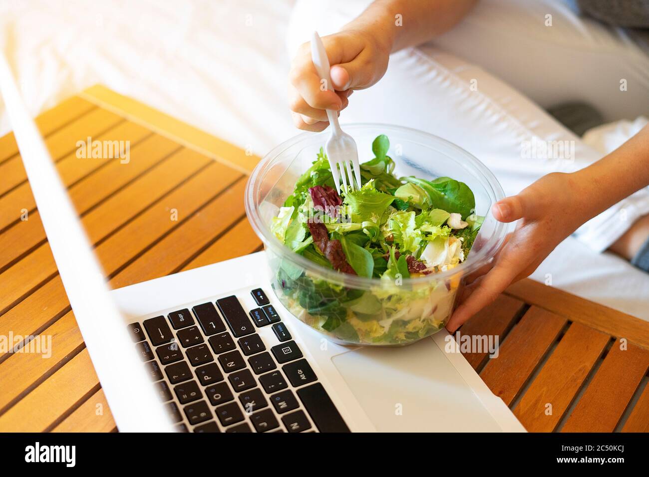 office worker eating a takeaway salad at work. Concept of healthy ...