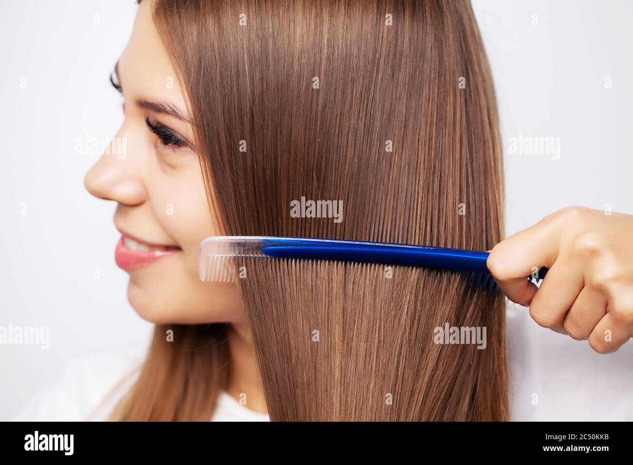 Young woman combs her beautiful hair with a comb Stock Photo - Alamy