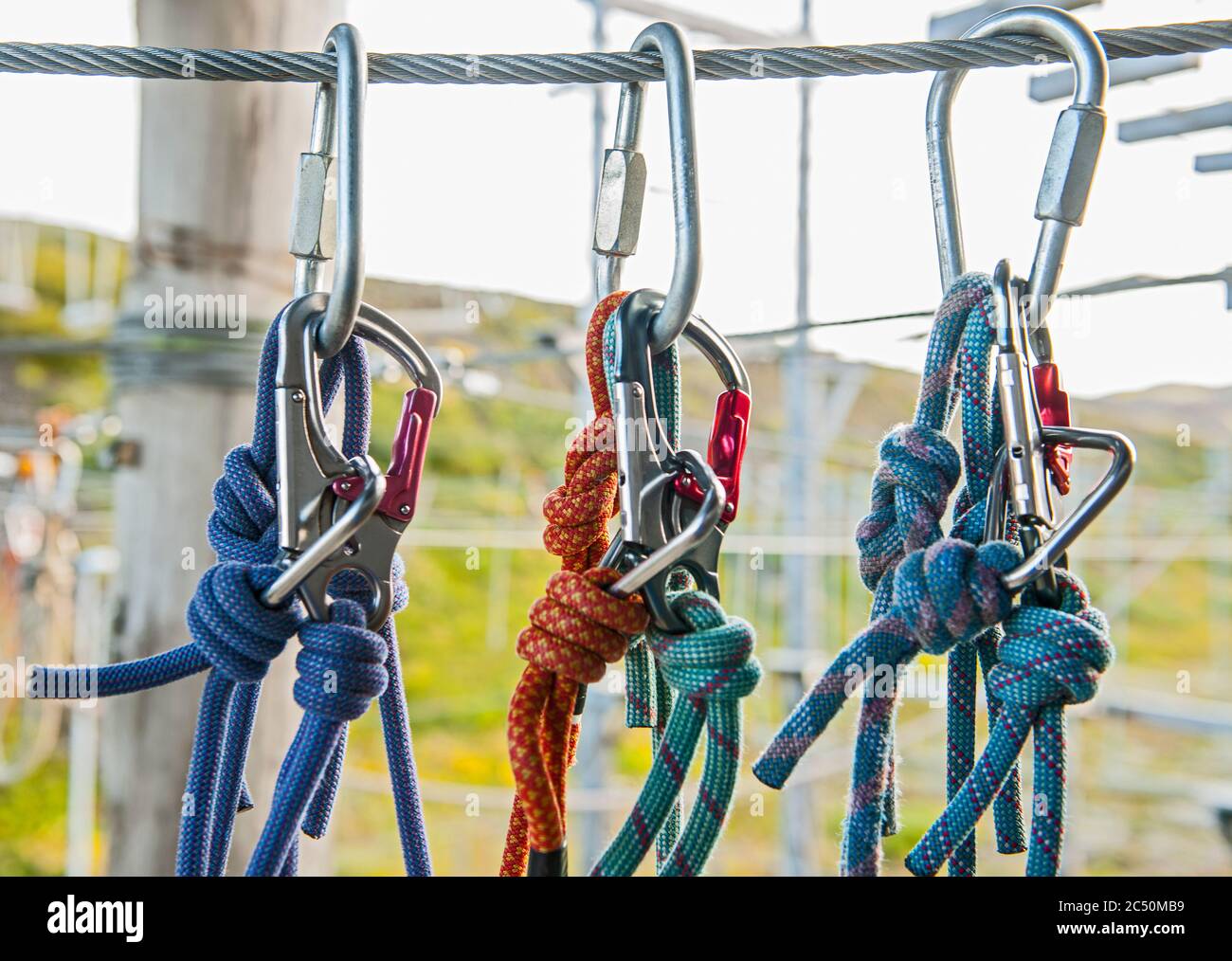 close up of carabiners on a metal wire at high rope obstacle course ...