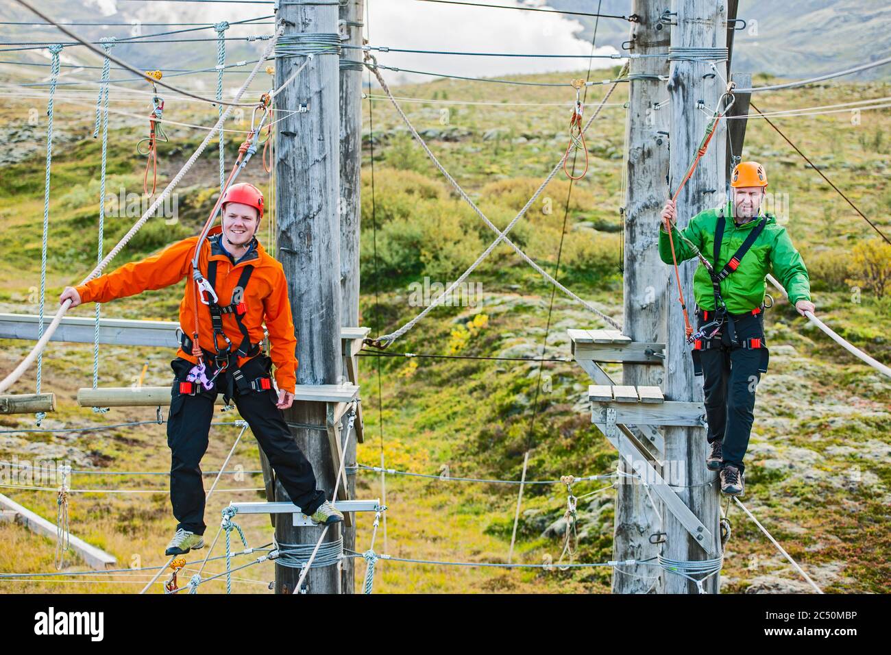 two men balancing on high rope obstacle course in Iceland Stock Photo ...