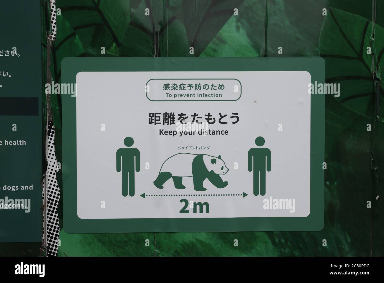 A "Keep your distance" sign is seen at the Ueno Zoological Gardens in ...