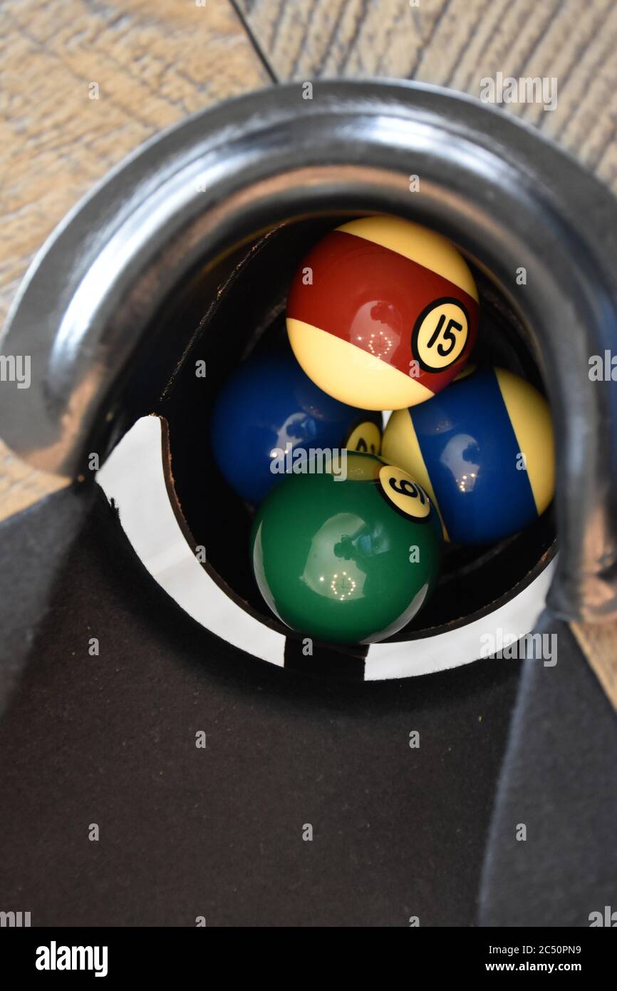 Black billiard table with balls. Balls in the hole. Closeup. Top view ...