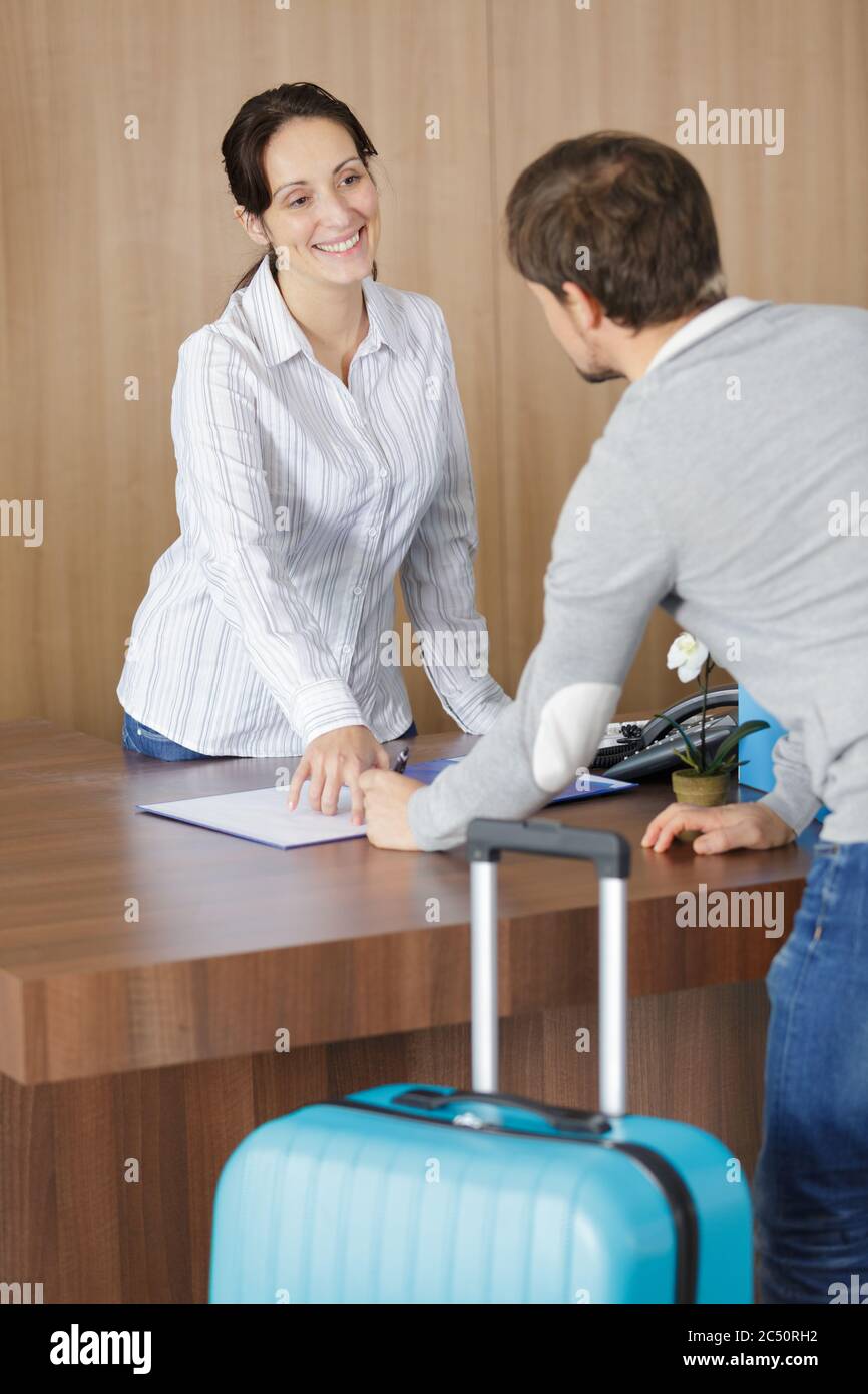 female hotel manager welcoming man Stock Photo - Alamy
