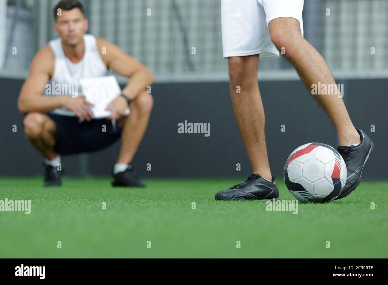 coach watching football player practice ball skills Stock Photo - Alamy