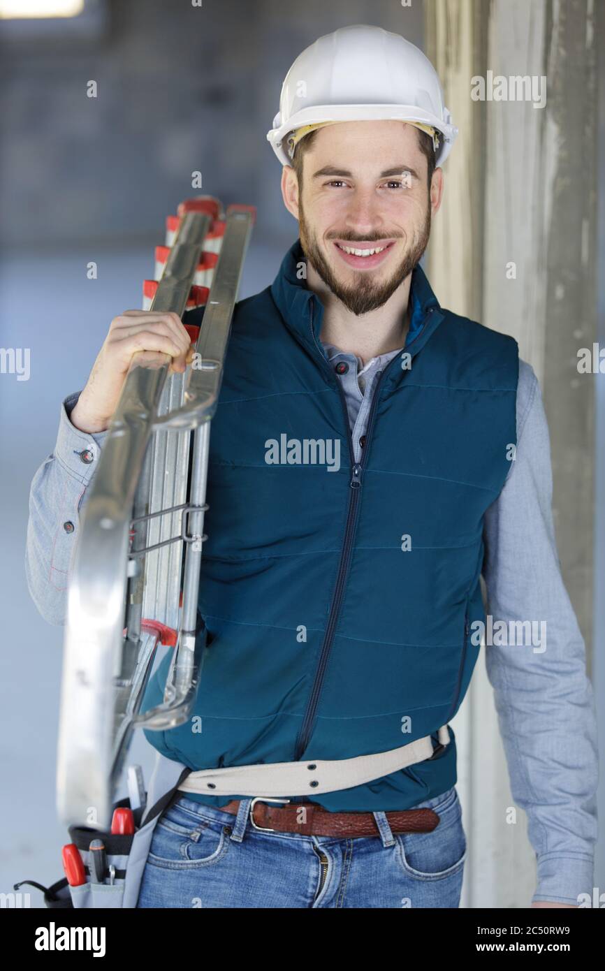worker at the construction site carries a ladder Stock Photo - Alamy